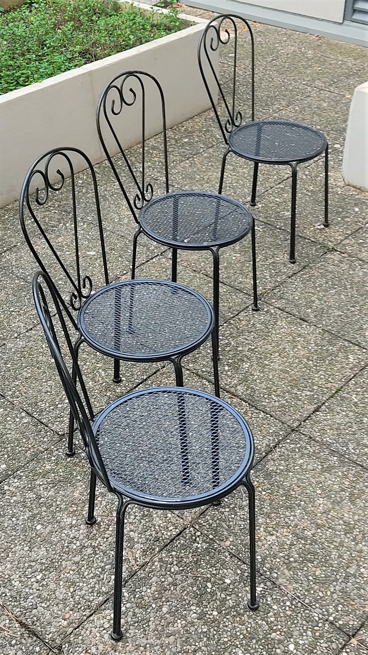Table ronde en fer forgé. D : 95 cm ; H : 75 cm et 4 chaises en acier ...