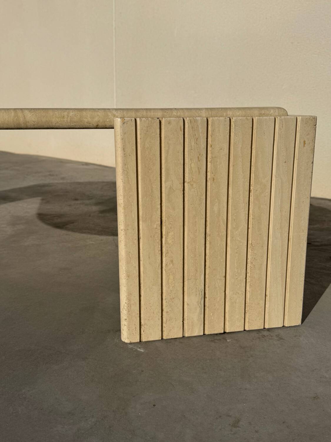 Large designer coffee table in travertine, eye shape, Roche Bobois edition from the 80s | Selency